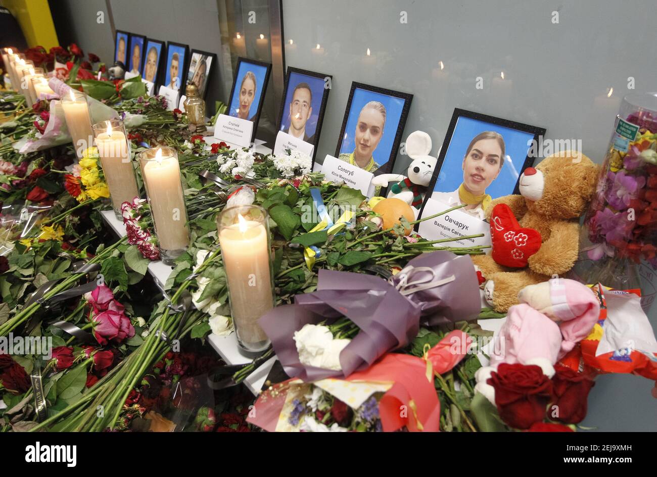 Flowers and candles are placed in front of the portraits of the victims ...