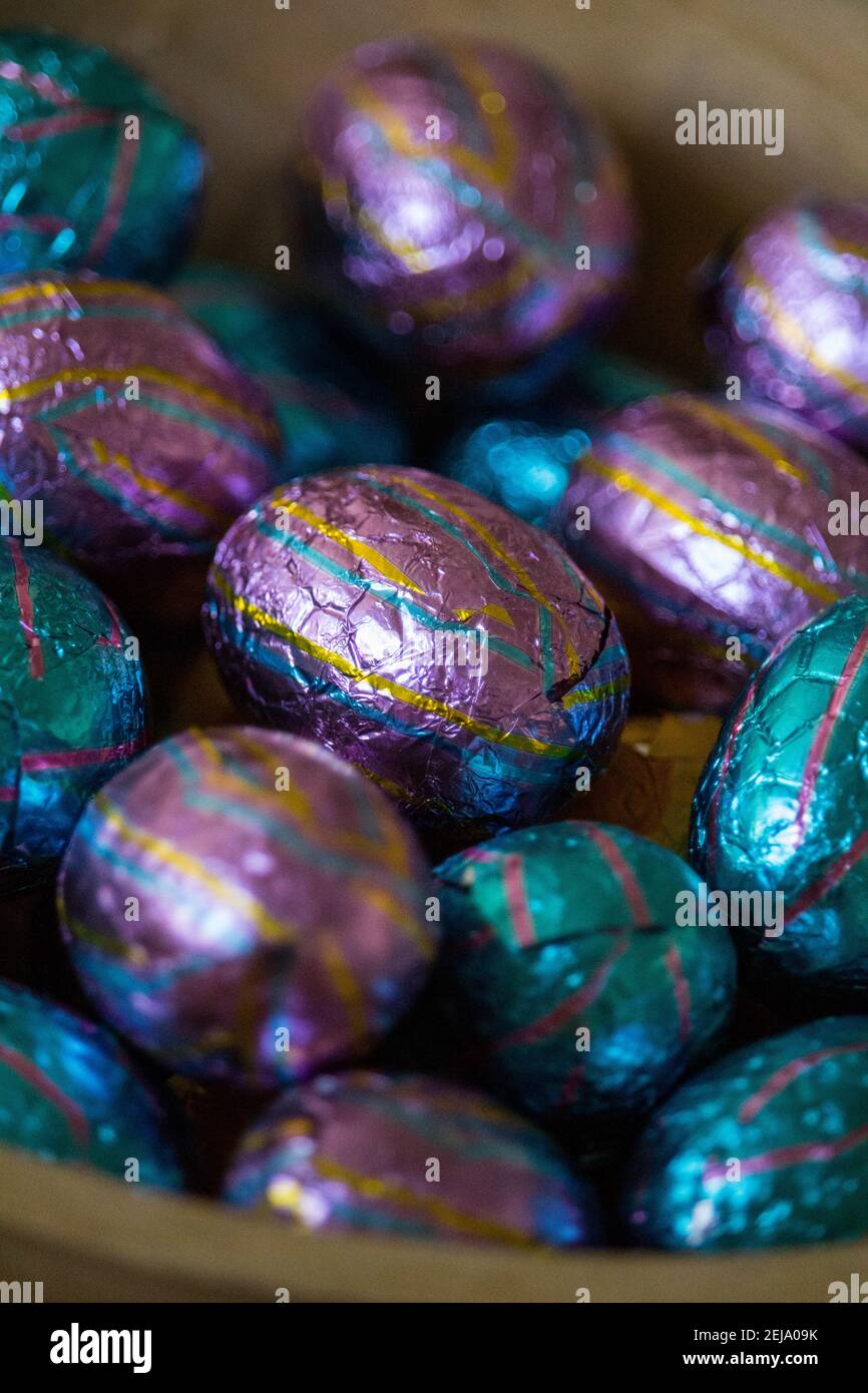Closeup shot of sweet chocolate eggs in a shiny colored foil wrapper ...