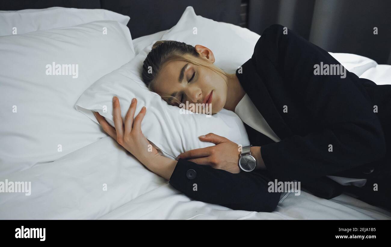 businesswoman in formal wear sleeping on bed in hotel room Stock Photo ...
