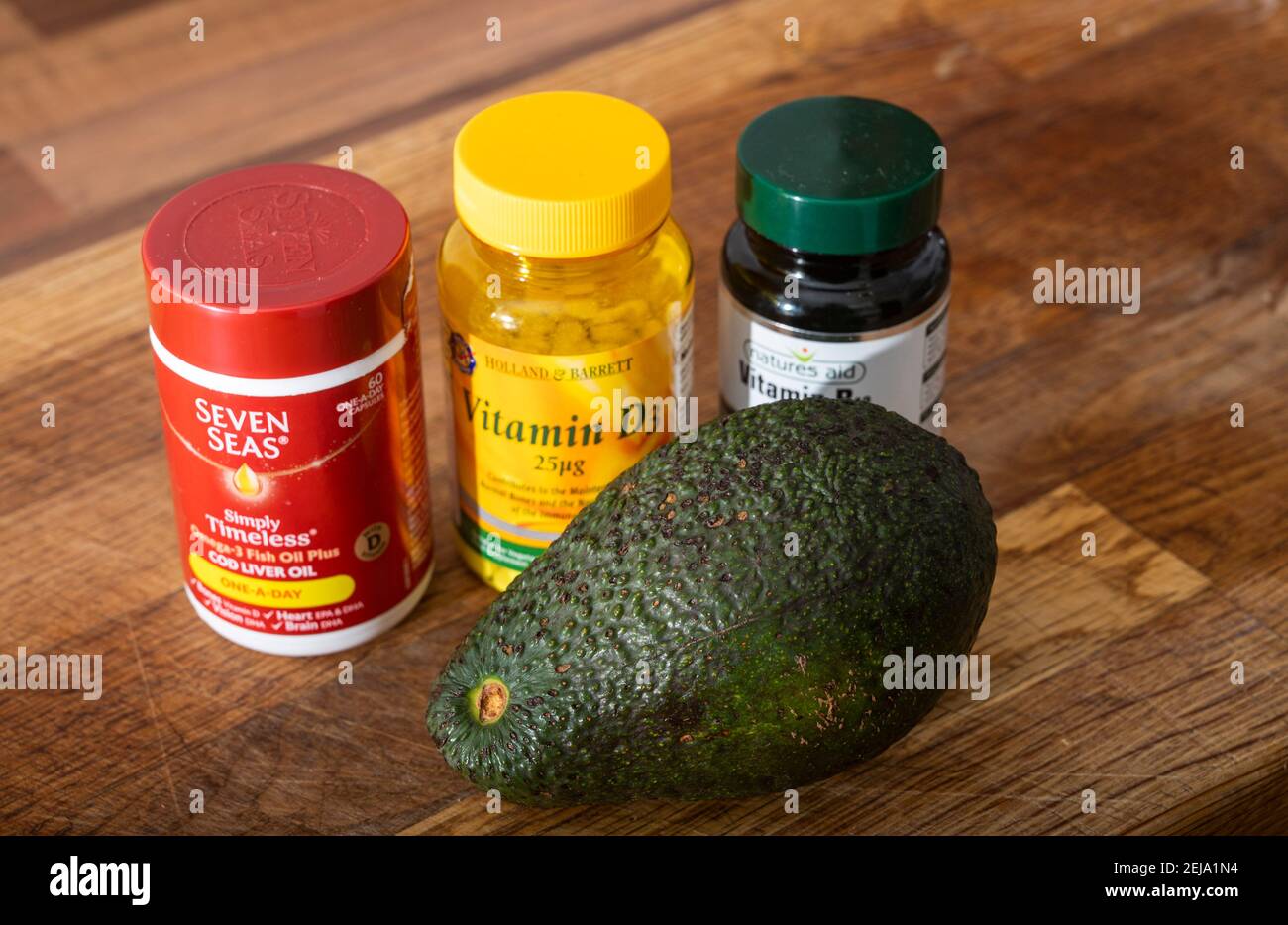 Various bottles of vitamin tablets and a fresh avocado pear from M&S ...