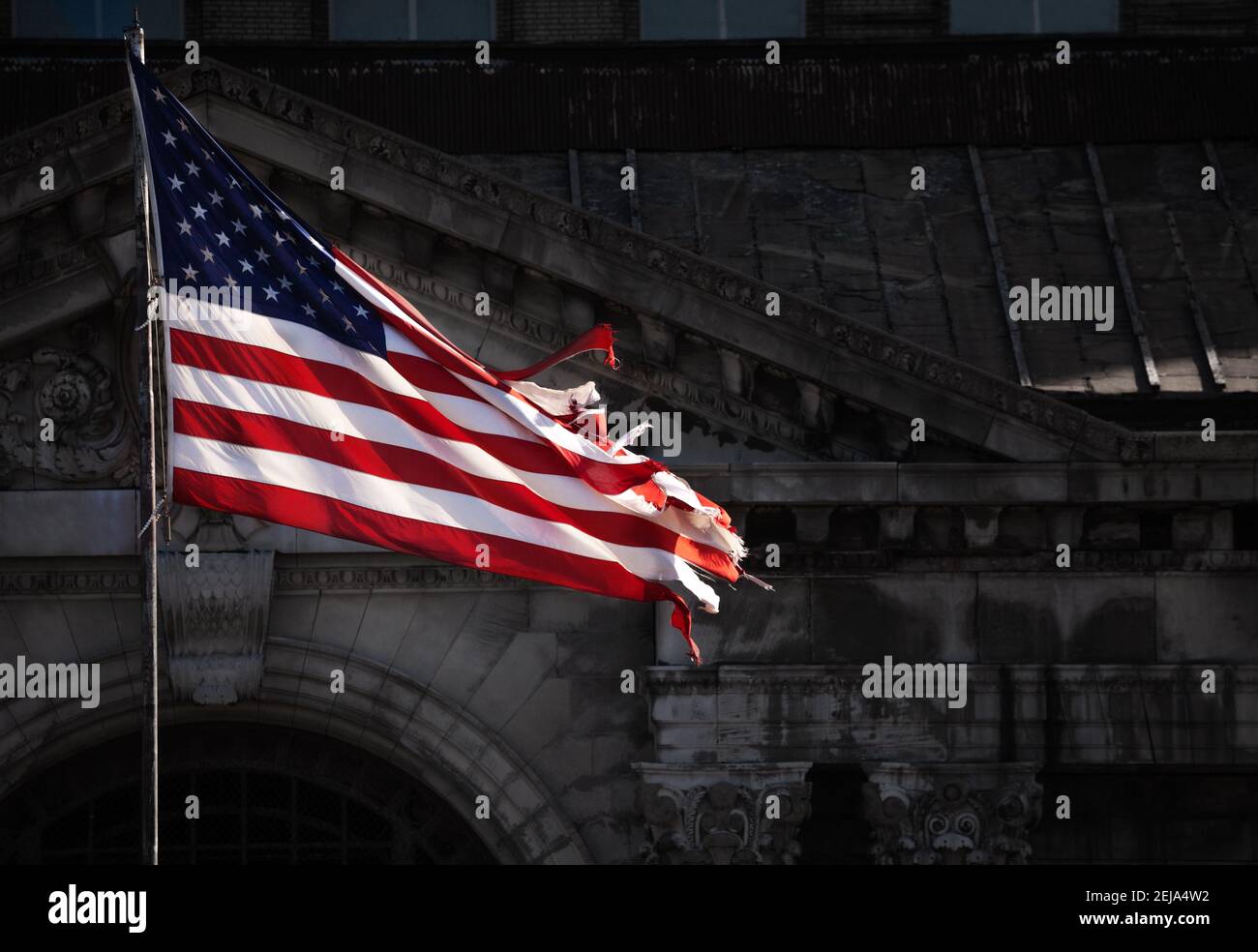 Moody image of a teared and faded USA flag in front of abandoned ...