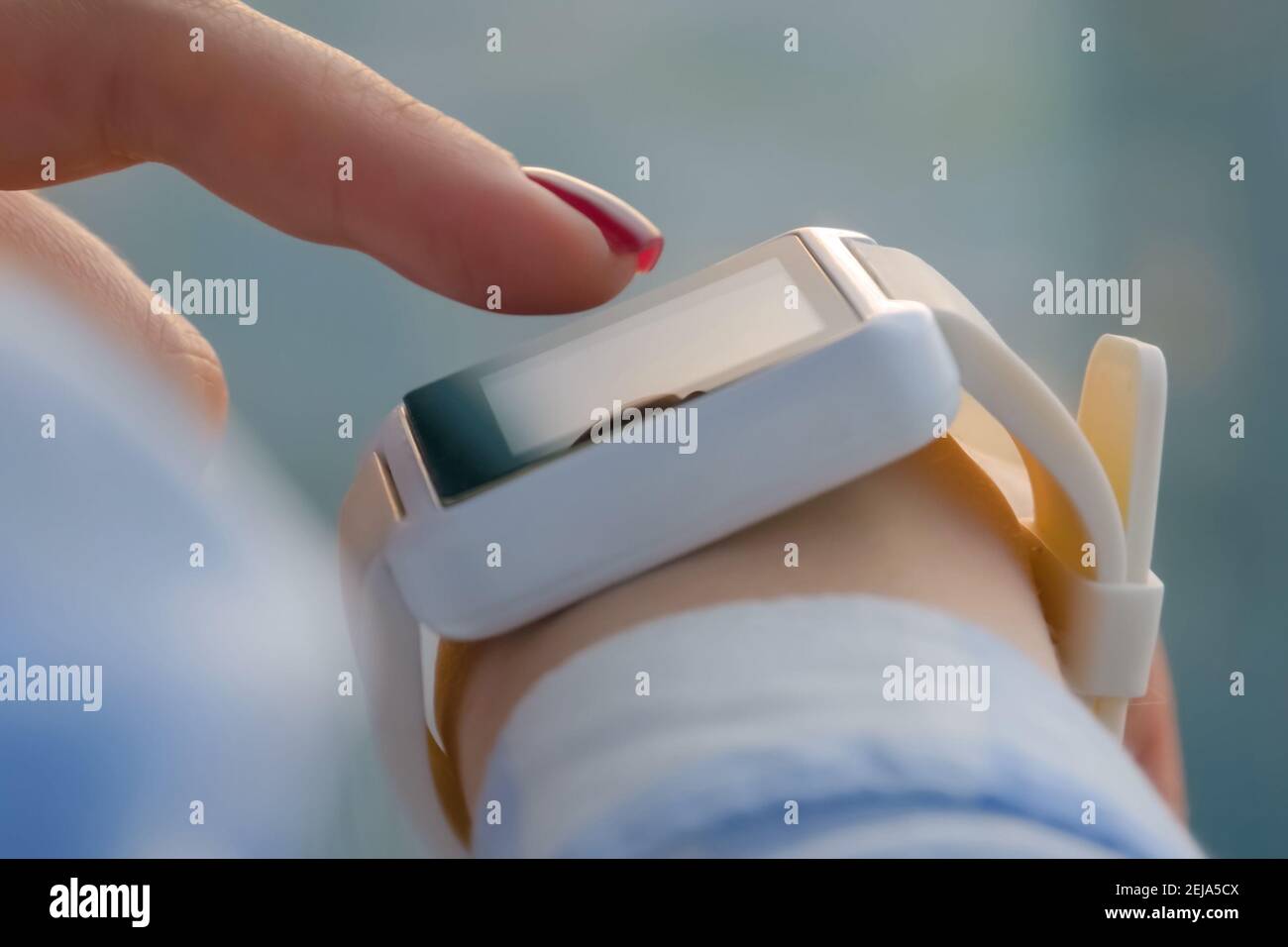 Woman using wearable white smart watch in office - close up side view ...