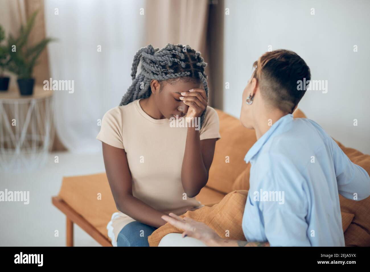 Girls talking and one of them looking frustrated Stock Photo - Alamy