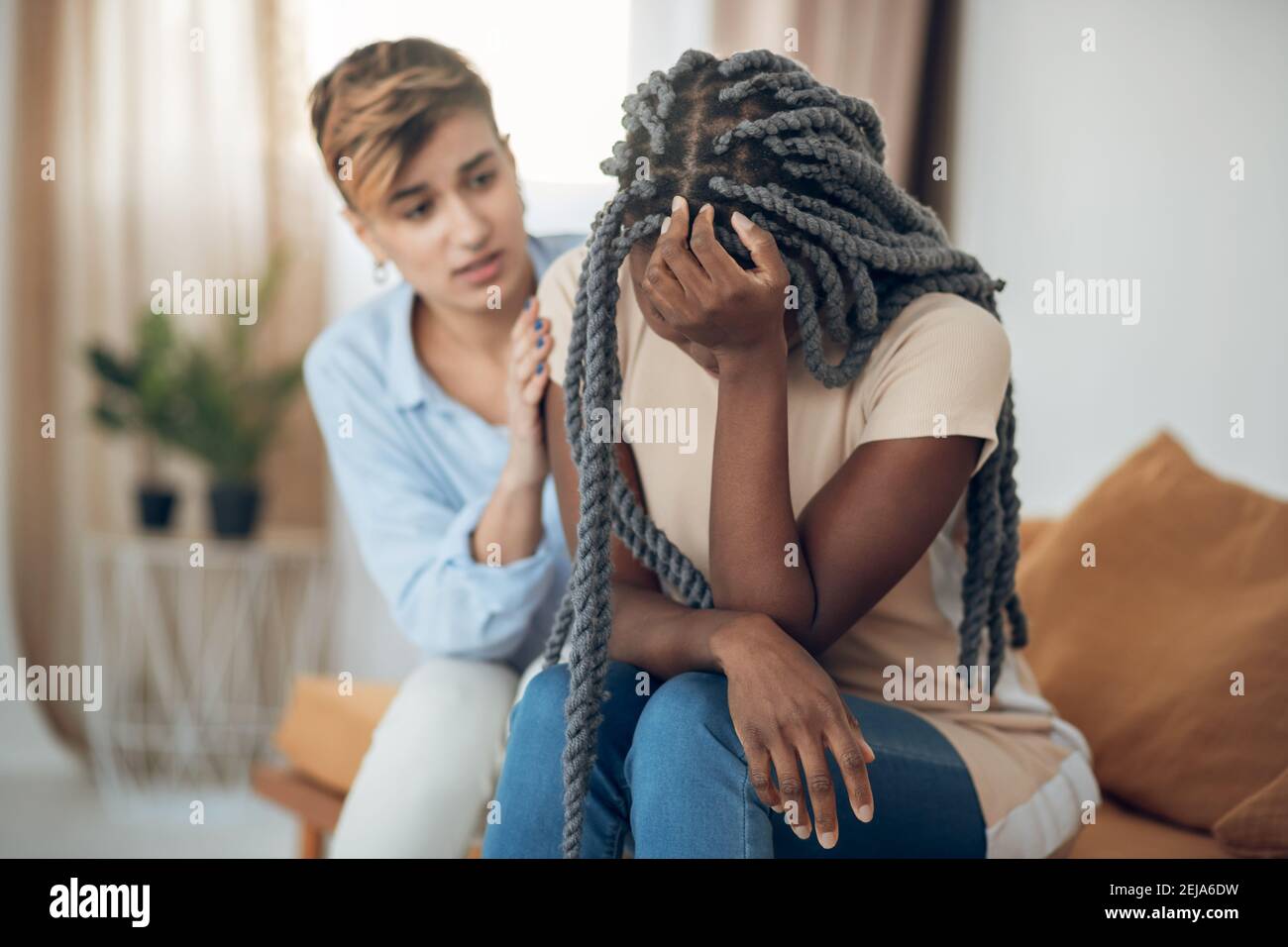 Girls talking and one of them looking frustrated Stock Photo - Alamy