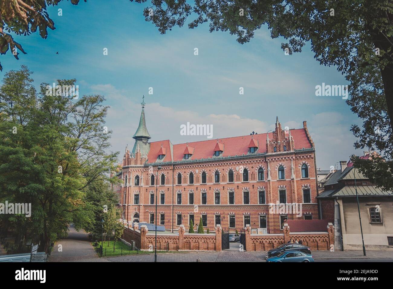 The Neo-Gothic building with orange brick wall and red roof with spire ...