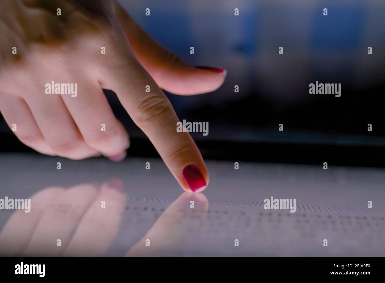 Woman finger using multimedia touchscreen display of interactive kiosk ...