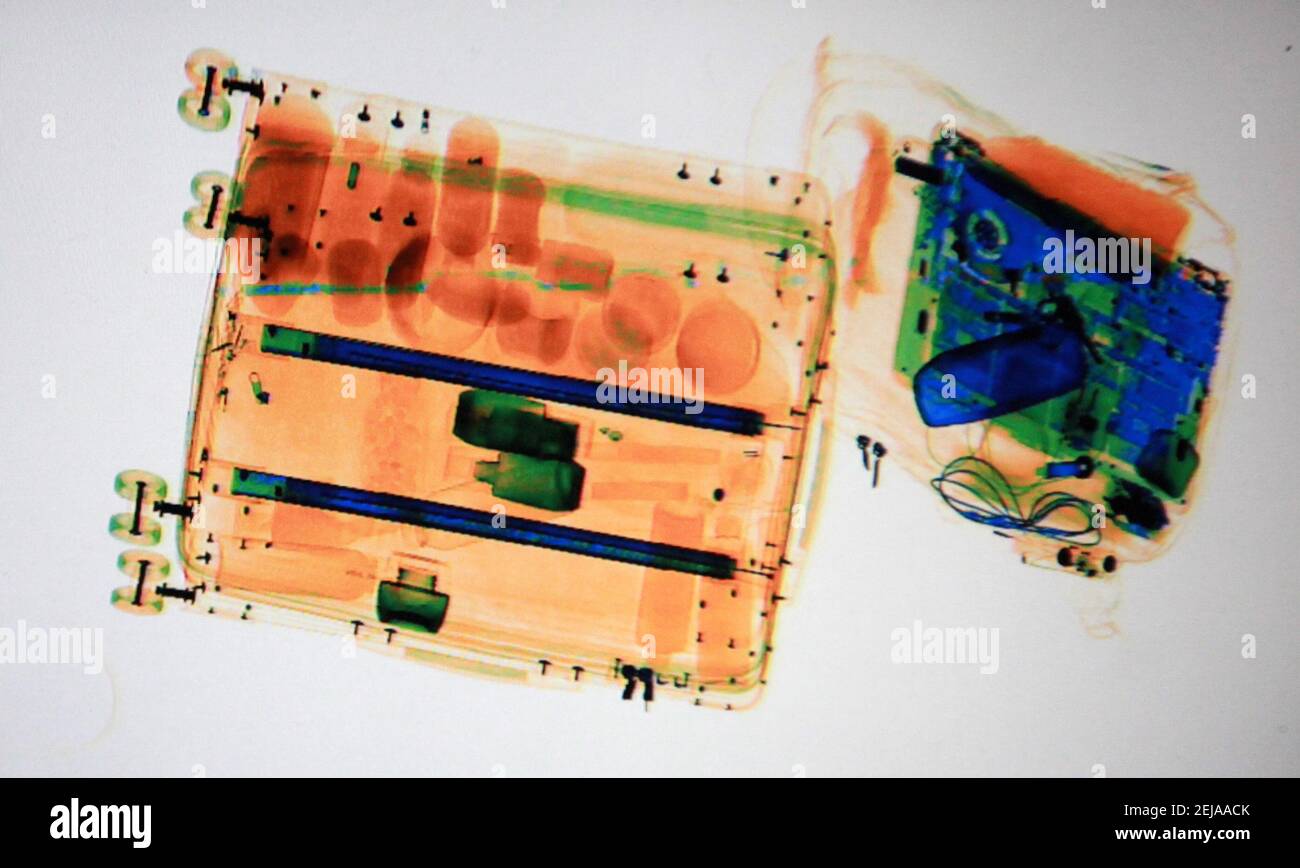 This X-ray picture shows a luggage and a bag passing through a scanning ...