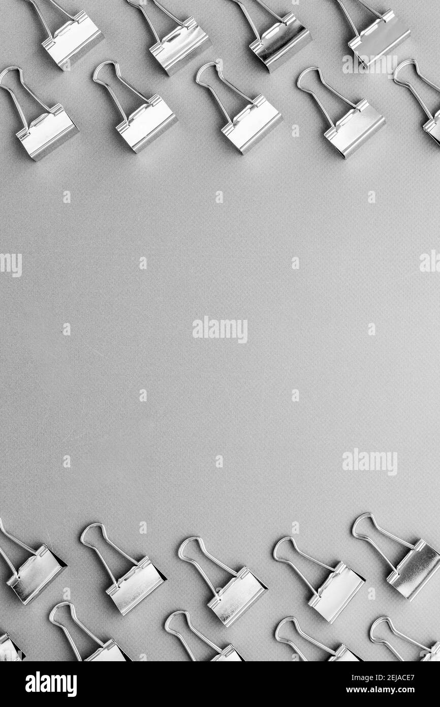 Frame of silver paper binder clips top view. Office supplies pattern ...