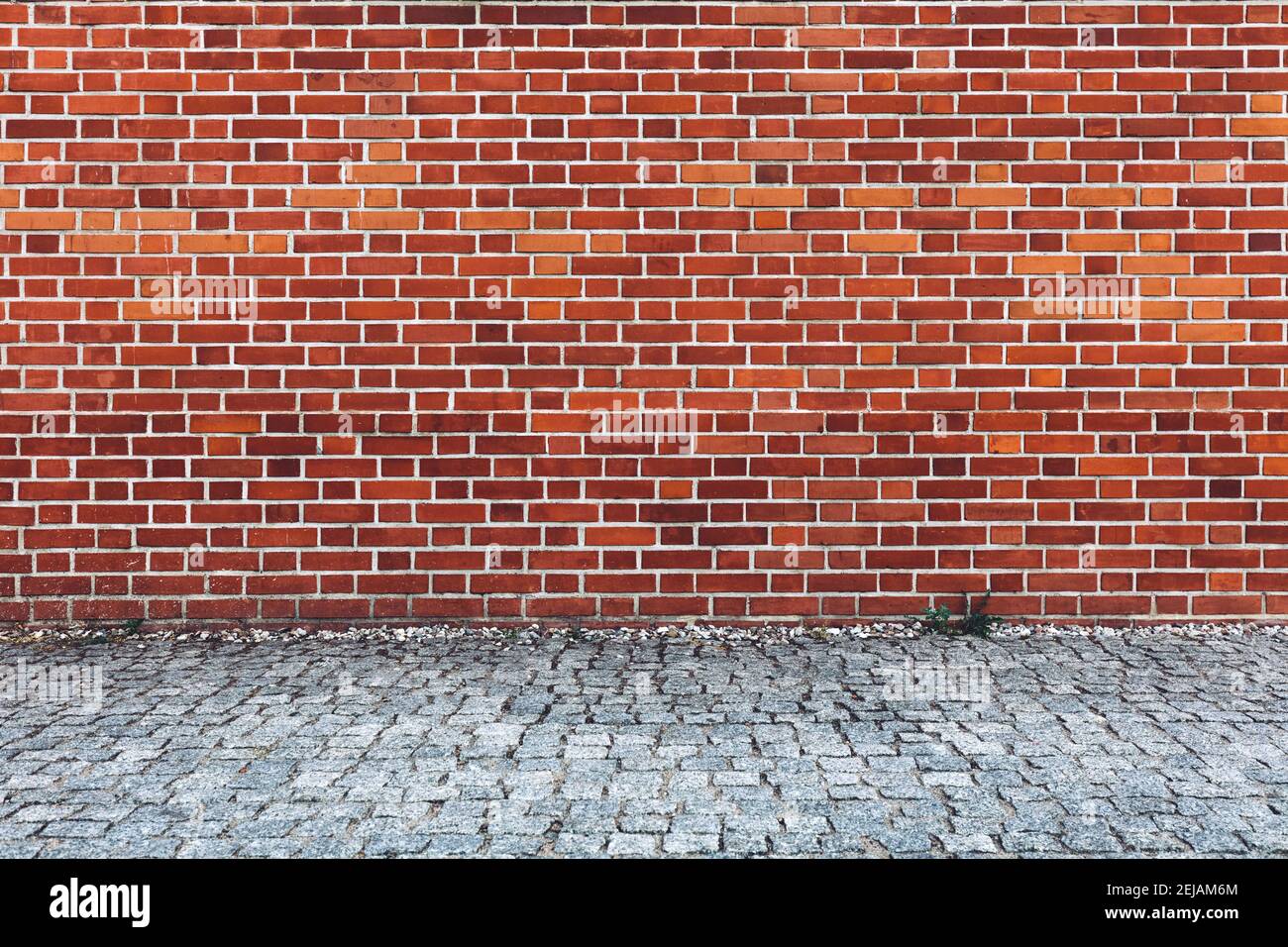 Retro red brick wall and cobblestone pavement. Background. Vintage ...