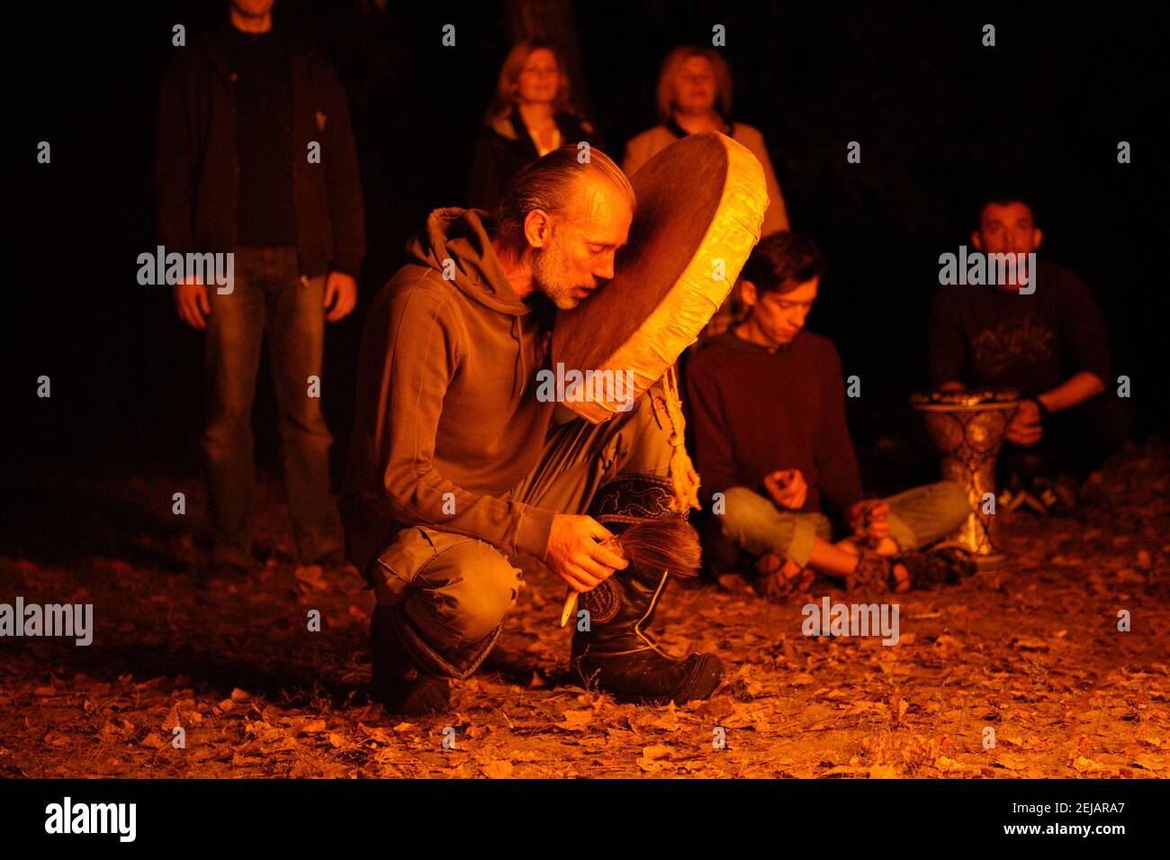 Slavonic shaman playing tambourine performing pagan ritual in front of ...