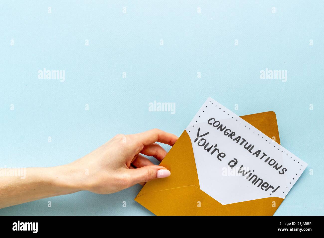 Female hand holds envelope with card You are a winner. Congratulations ...