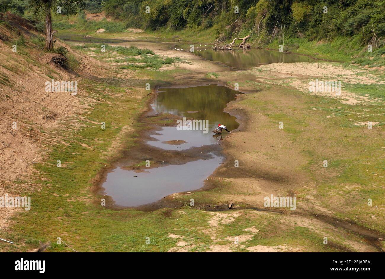 A villager walks around a dry Yom River during a drought season (now ...