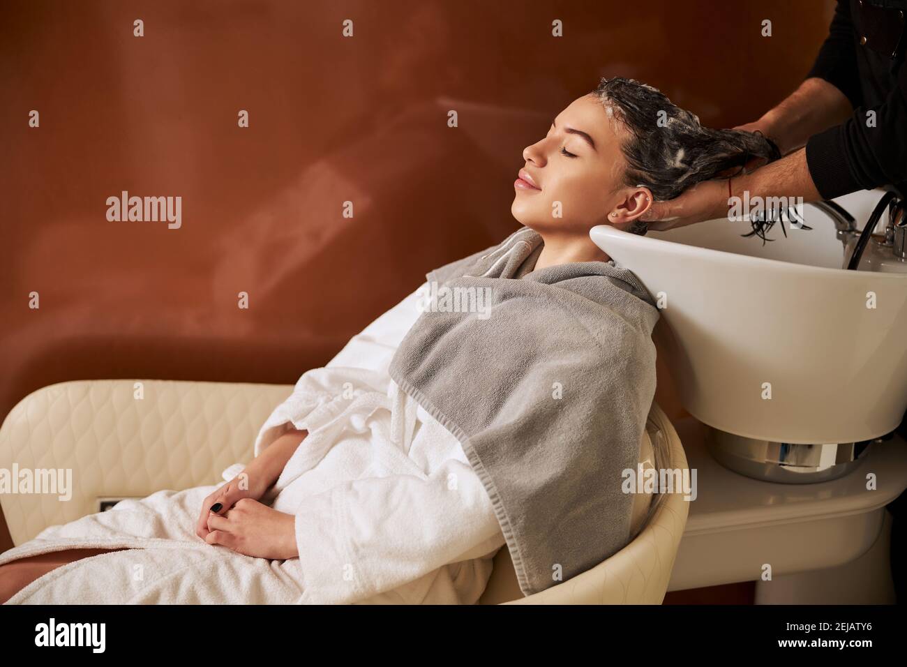 Professional male stylist washing a woman head Stock Photo - Alamy