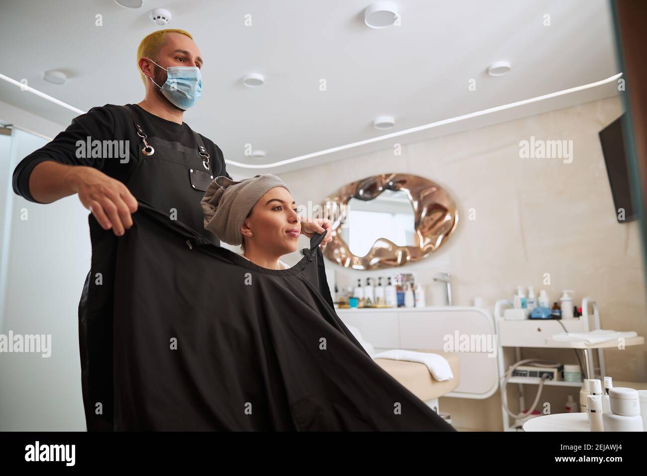 Straw-haired stylist preparing a woman for a haircut Stock Photo - Alamy