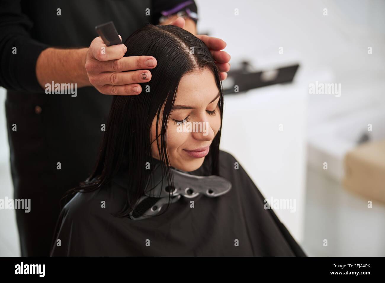 Stylist hands with a comb placed on his client hair Stock Photo - Alamy