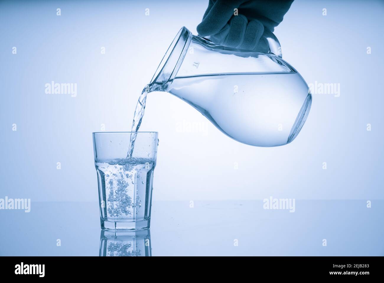 Pitcher with drinking water and a glass with a drink, blue tone Stock ...