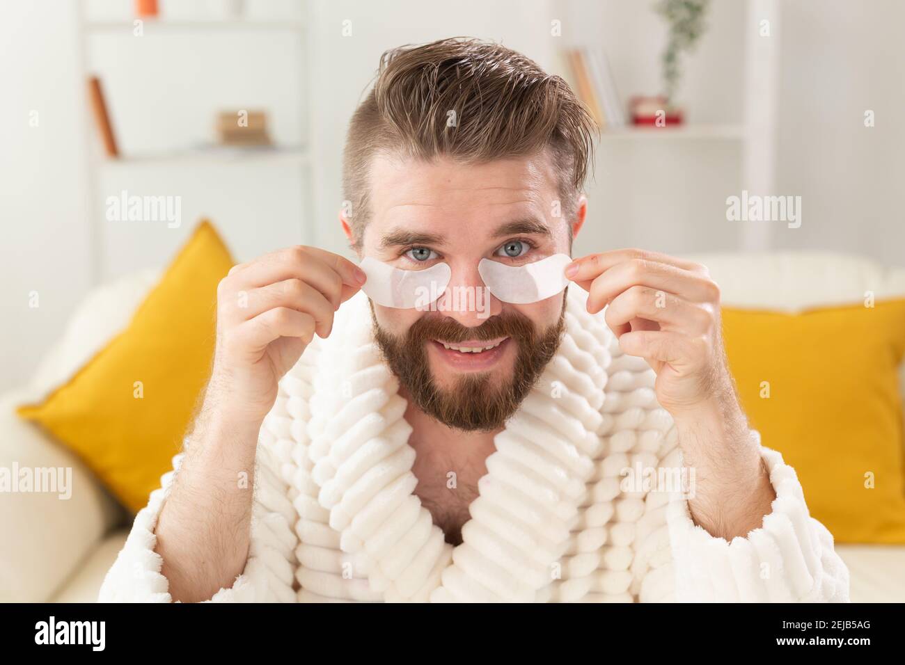 Bearded man removing eye patches on his face. Wrinkles and face home ...