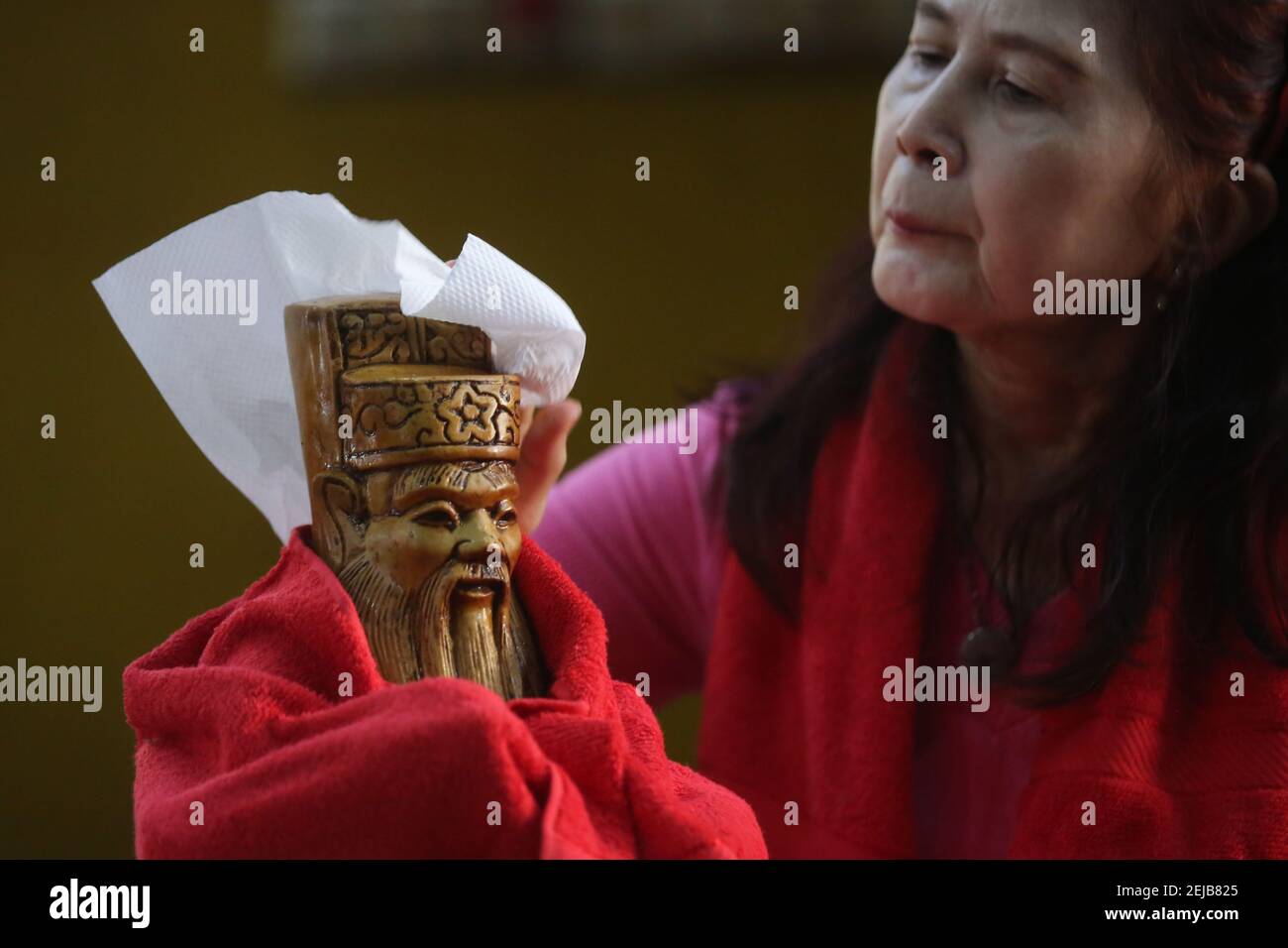 A woman cleans a statue during the celebration at the Amurva Bhumi ...