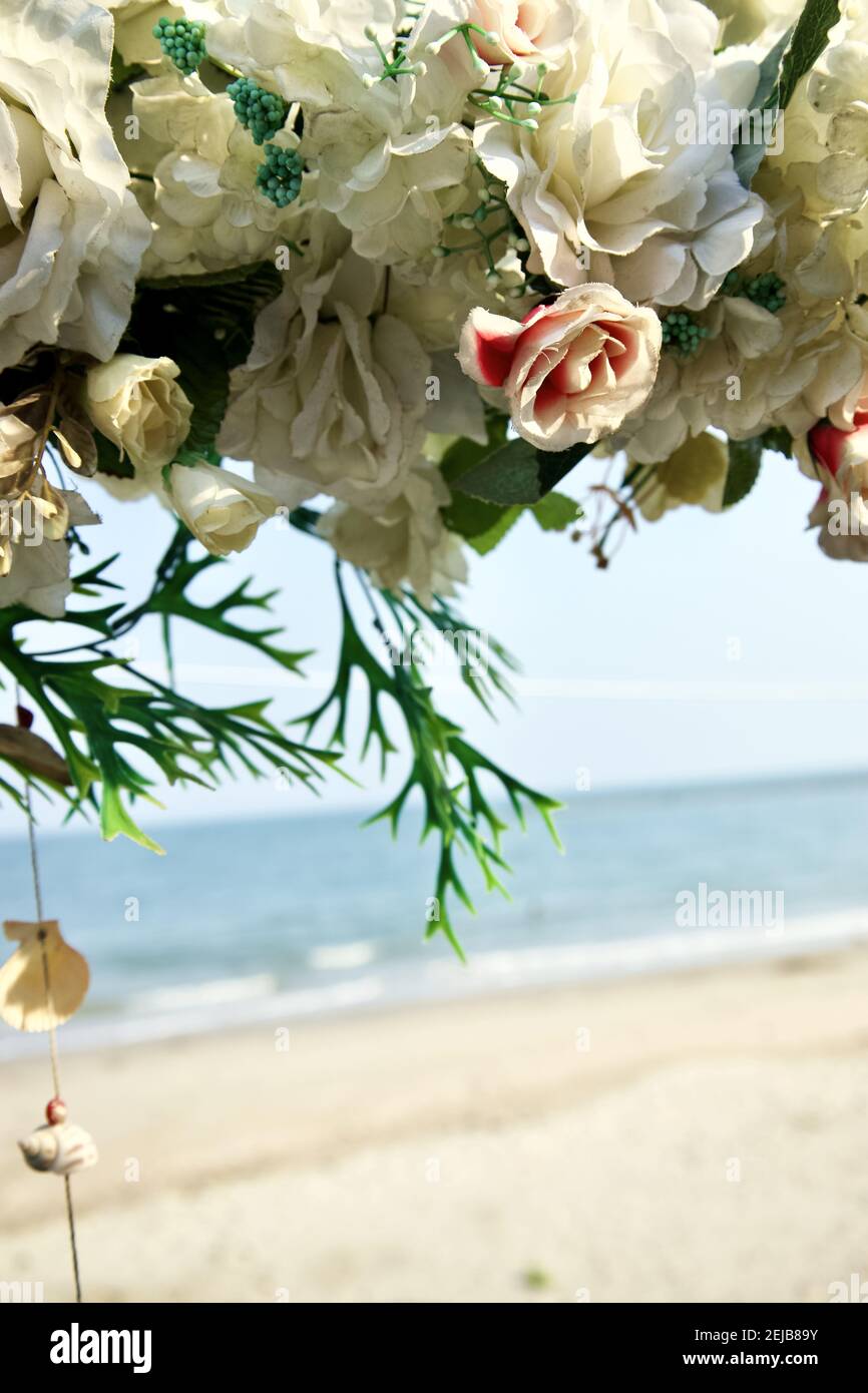 Decorative flowers and seashells on rope lines at the beach in ...