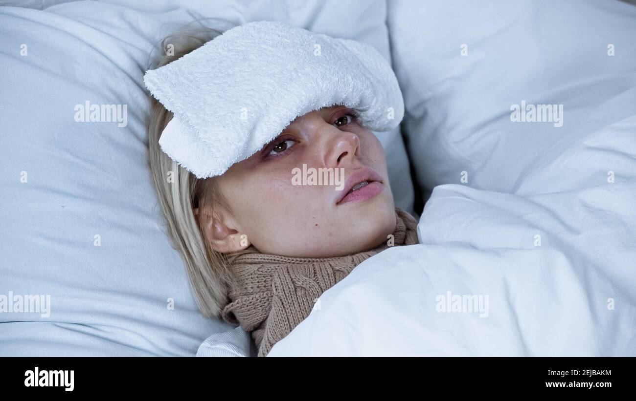 young diseased woman lying in bed with compress on forehead Stock Photo ...