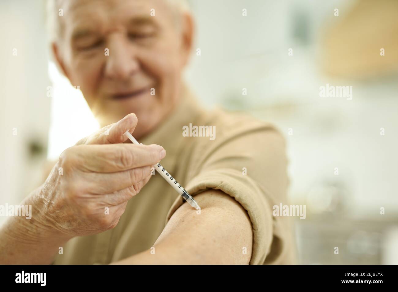 Selective focus photo of a senior man having his sleeve rolled up and ...