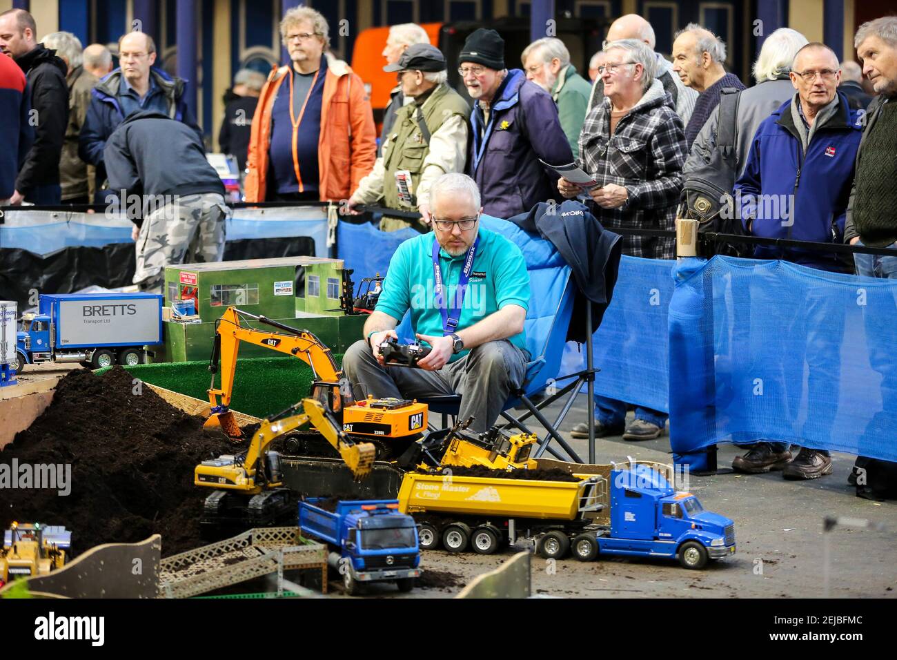 An exhibitor operates miniature building trucks during the exhibition ...
