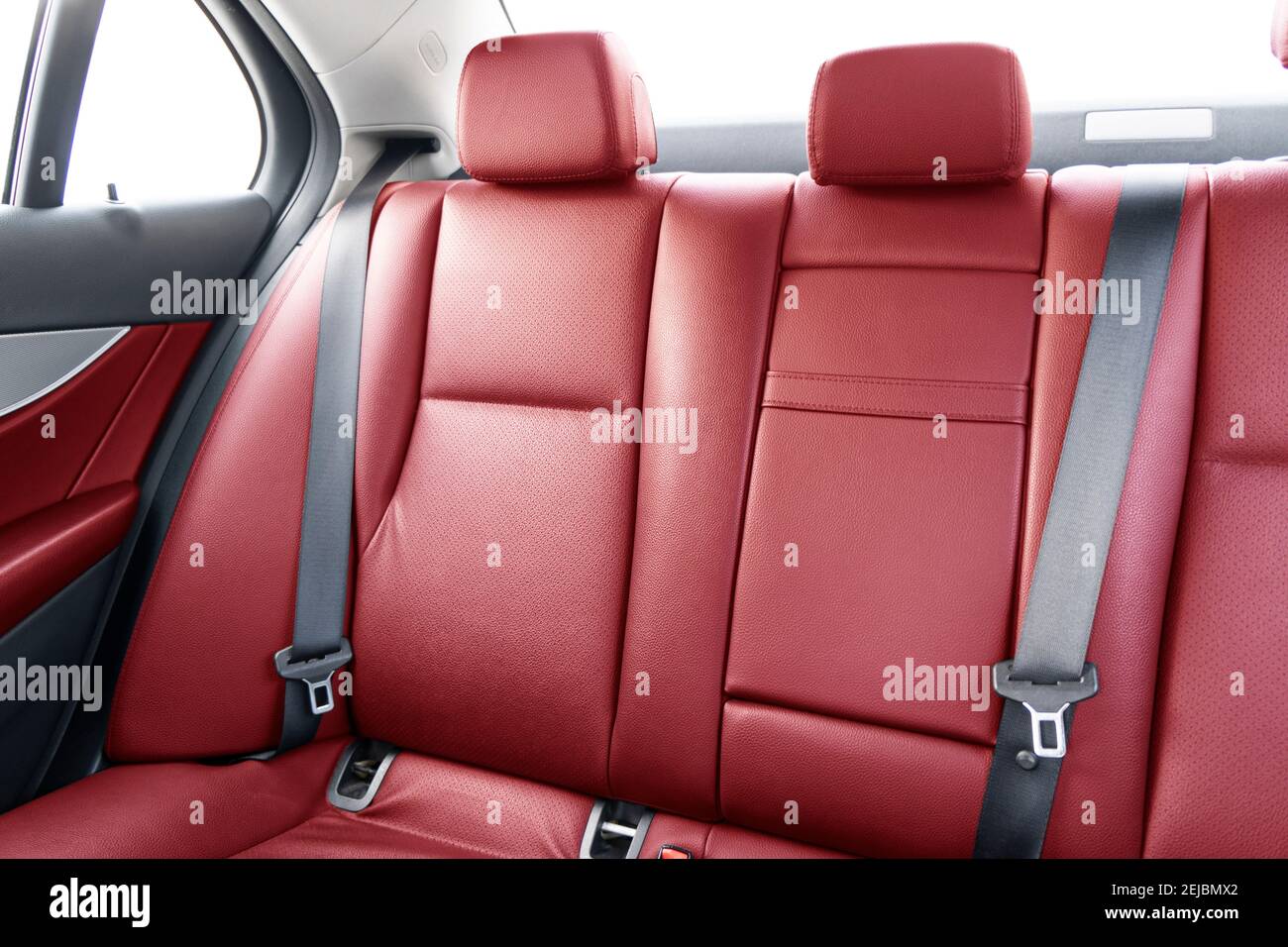 Back passenger red leather seats in modern luxury car. Red perforated ...