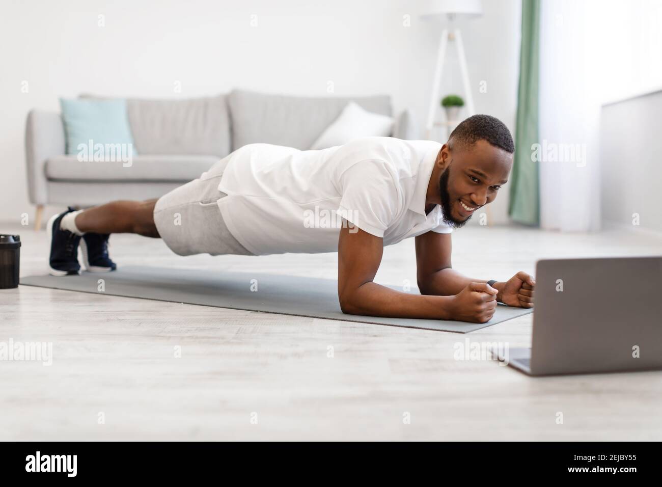 Black Man At Laptop Standing In Plank Exercising At Home Stock Photo ...
