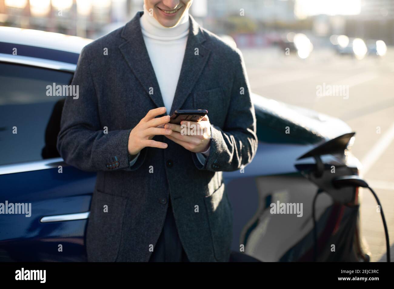 Close up cropped shot of handsome young guy standing near his luxury ...