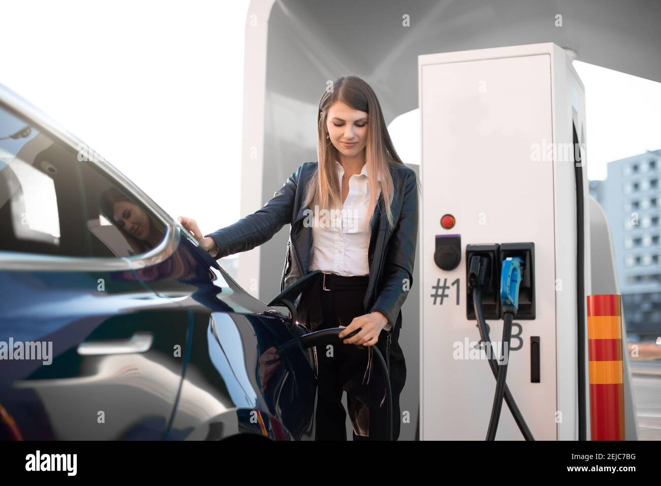EV charging station, eco fuel concept. Portrait of pretty young girl ...