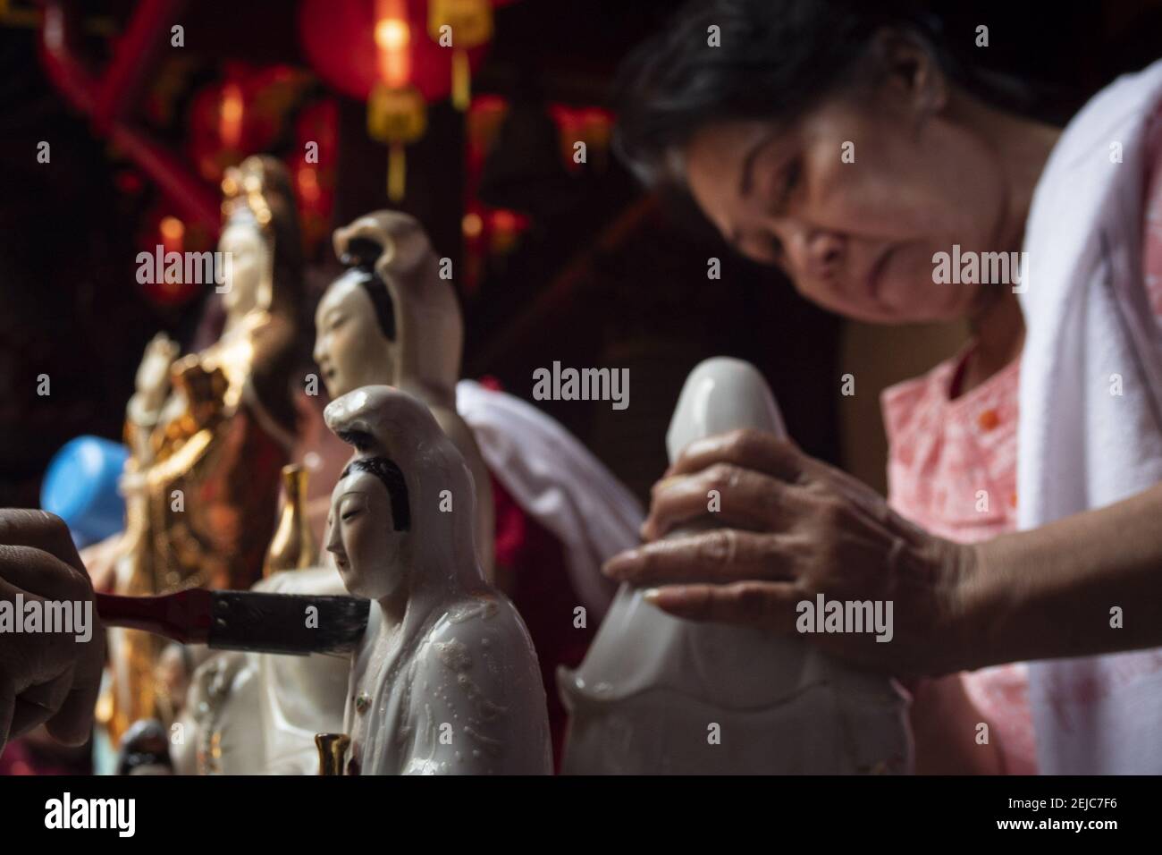 A woman cleans a statue during the celebration at Dhanagun Temple in ...