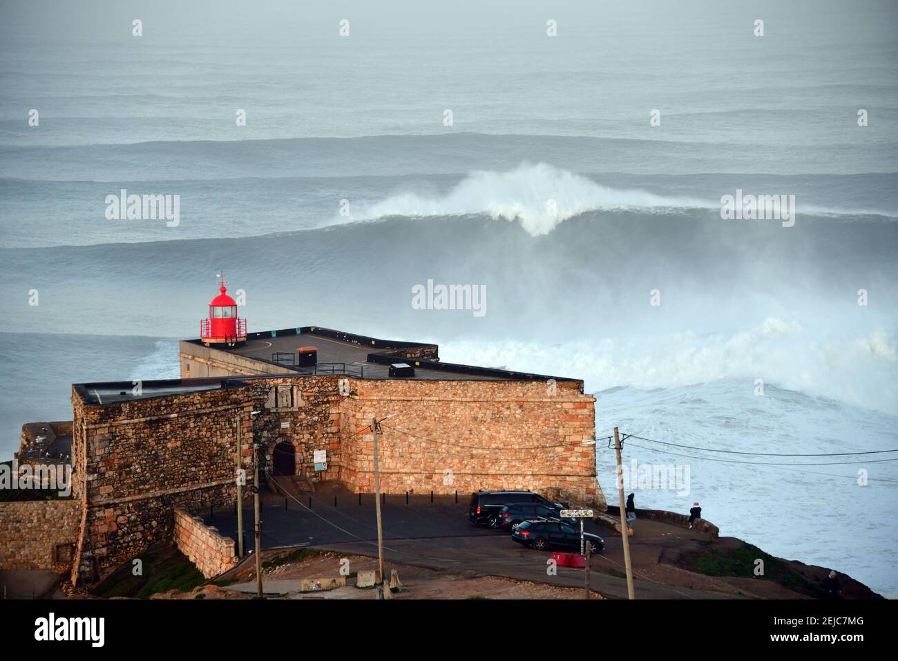 Huge wave breaking with Farol da nazare in the foreground Stock Photo ...