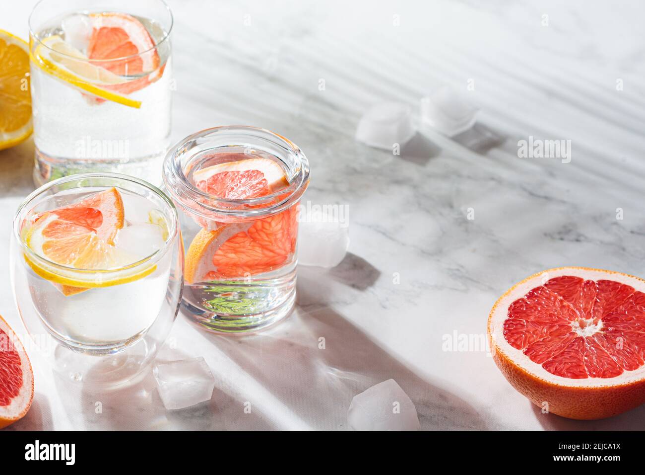 Glasses of water with grapefruit and lemon. Fresh citrus sassy water ...