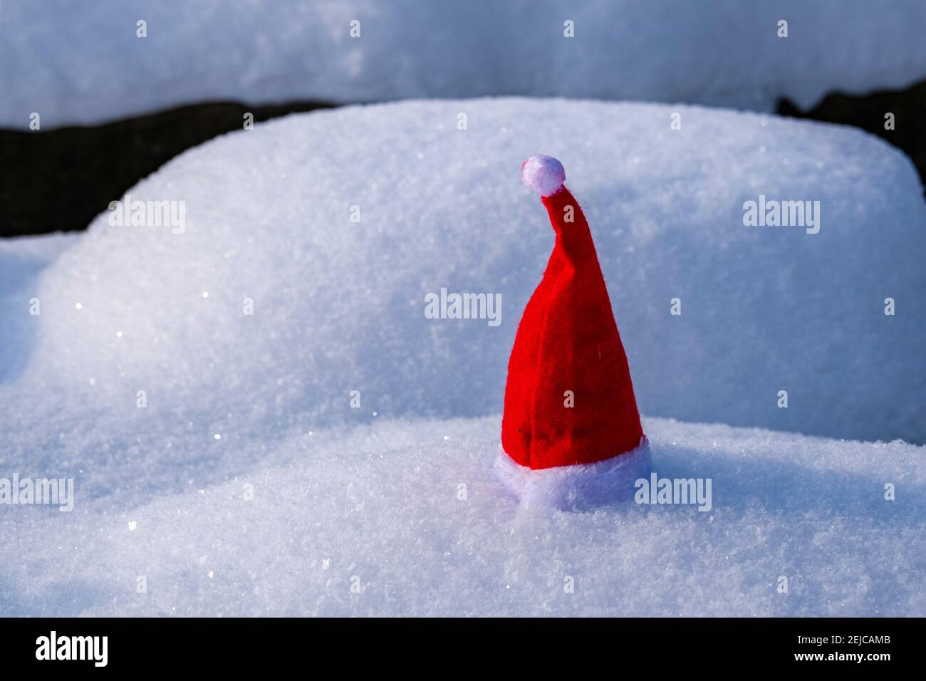 A small red christmas cap placed on snow Stock Photo - Alamy
