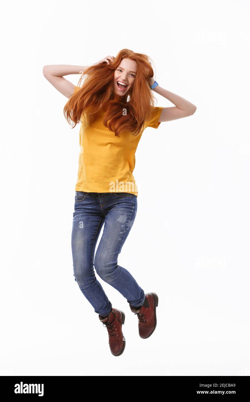 Full length portrait of a cheerful cute woman jumping isolated on a ...