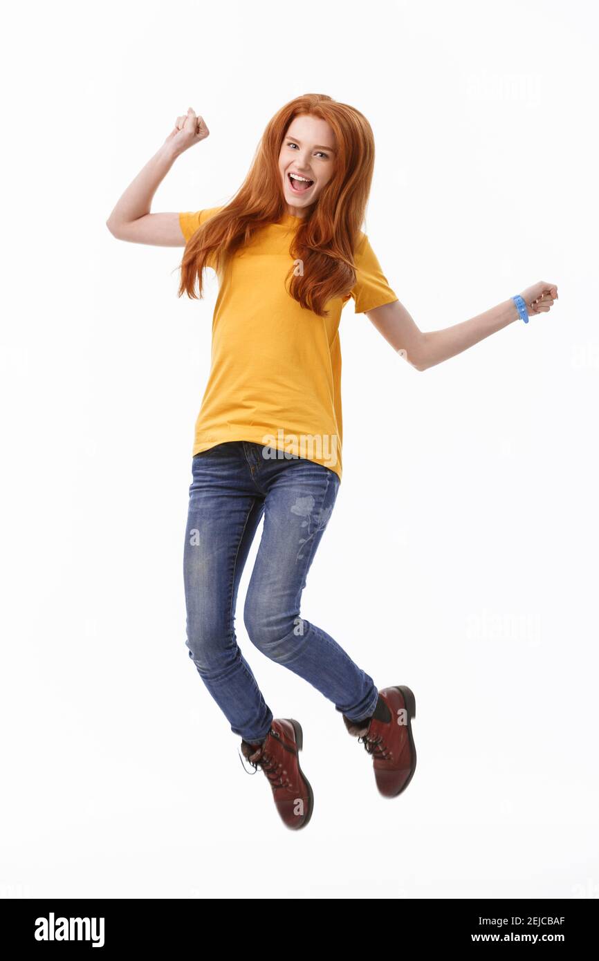 Full length portrait of a cheerful cute woman jumping isolated on a ...