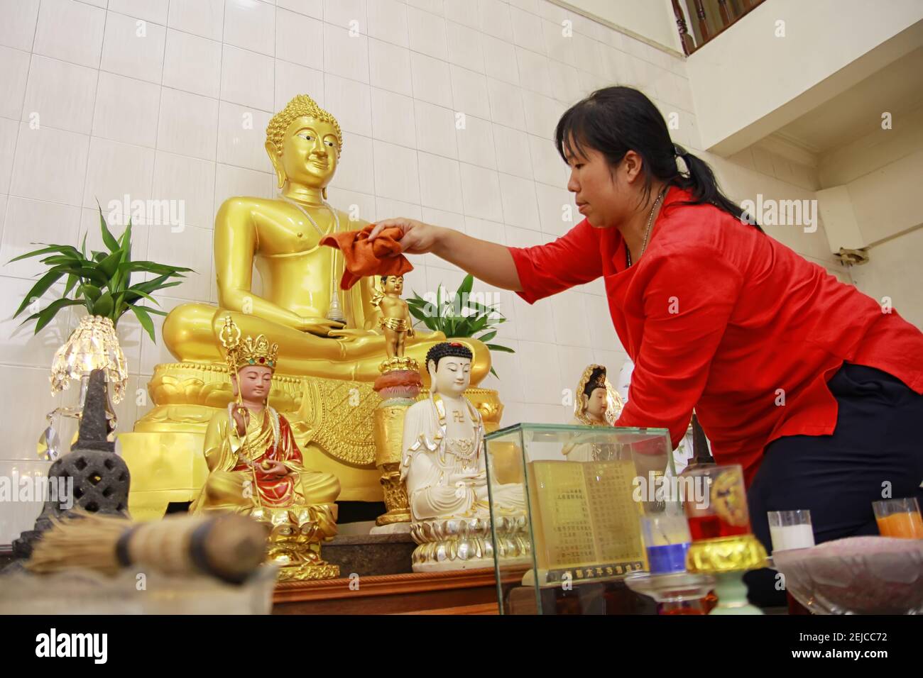 A woman cleans a buddhas statue during the celebration at Sakyamuni ...