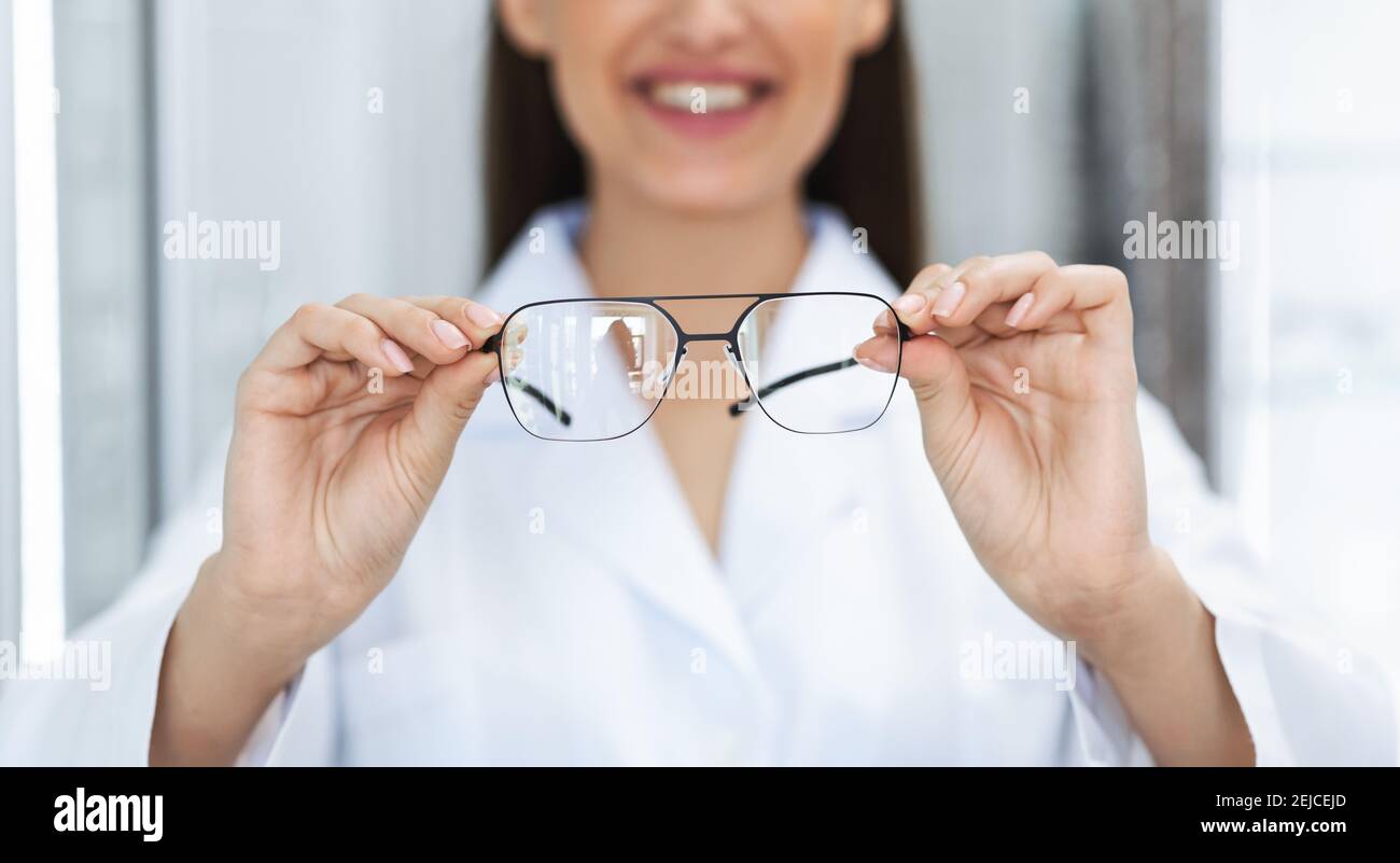 Closeup portrait of young optician showing spectacles to camera Stock ...