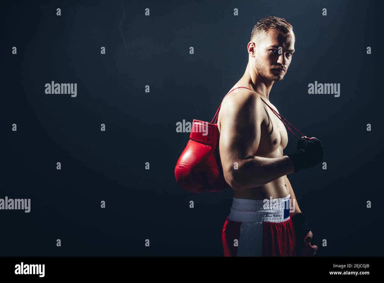 Fighter standing with gloves hanging over his back. Professional ...