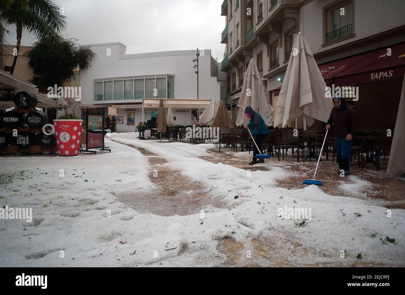 People clear hail from their workplace after a heavy hailstorm in ...