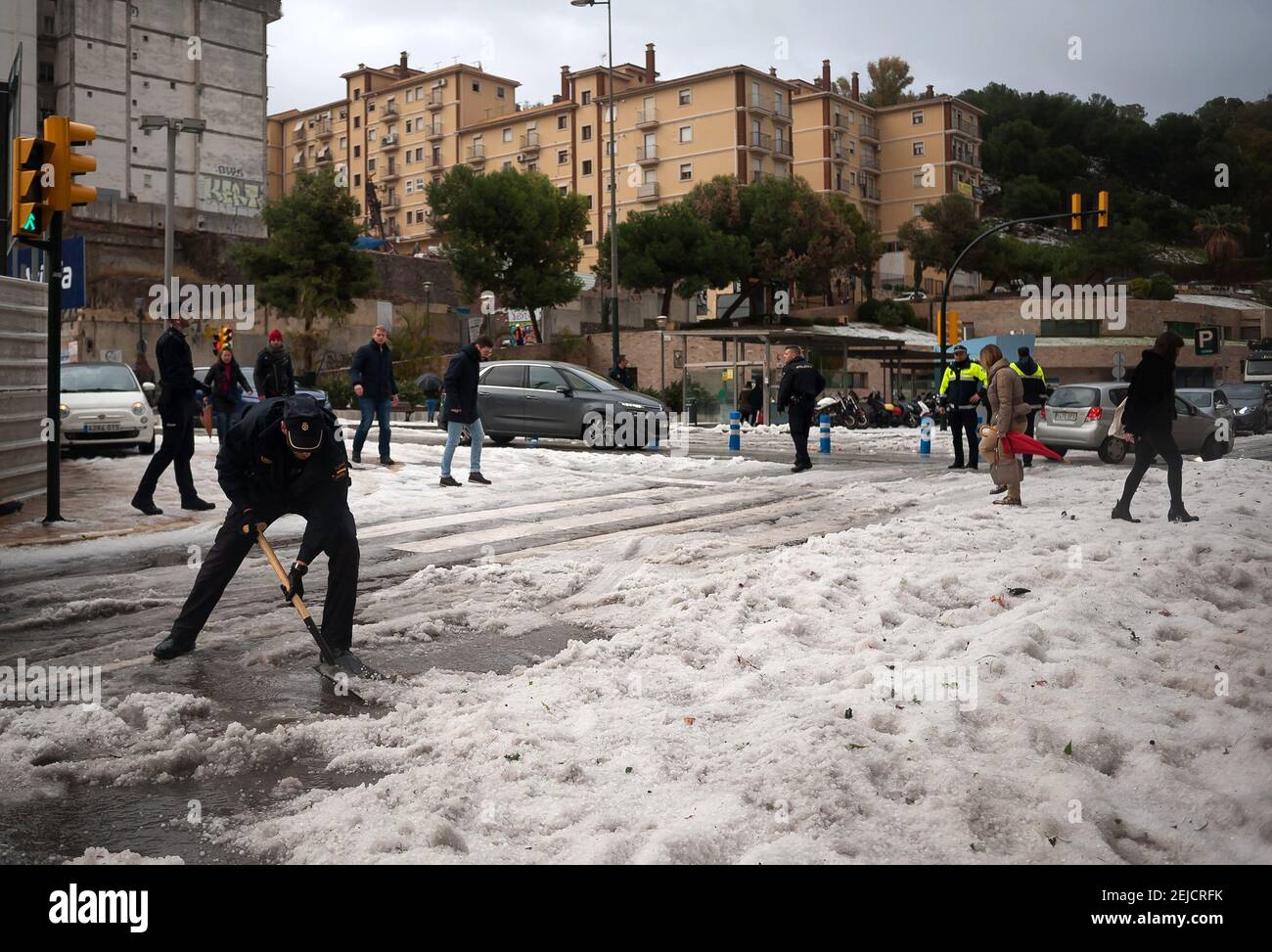 A Spanish national policeman clears hail from road after a heavy ...