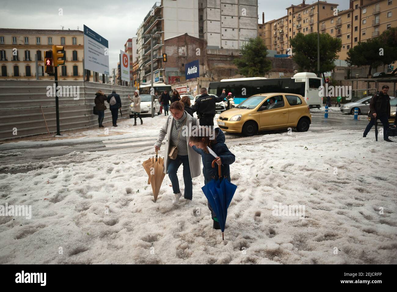 Women walk on hail while holding umbrellas after a heavy hailstorm in ...