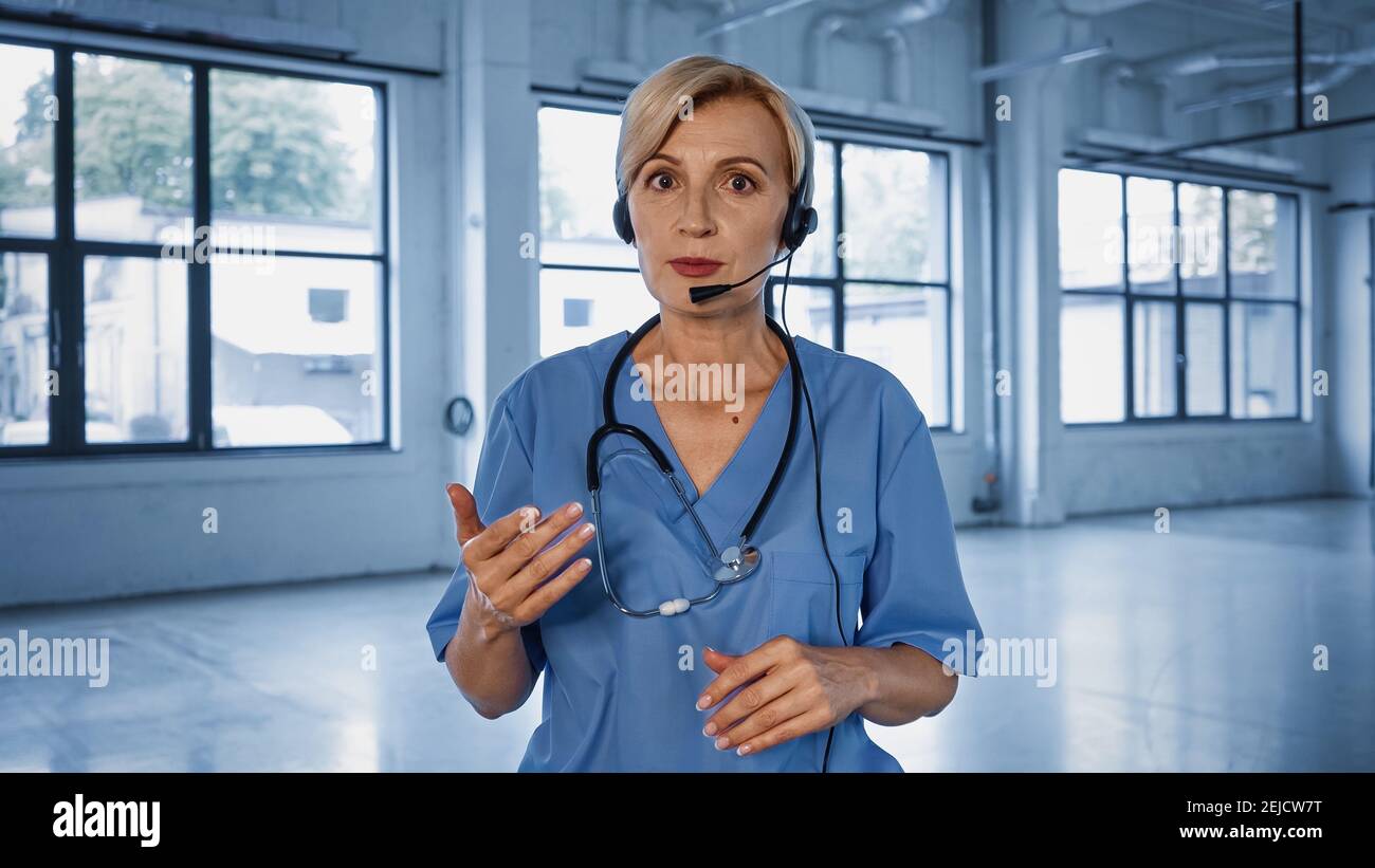 Doctor in headset talking at camera in hospital Stock Photo - Alamy