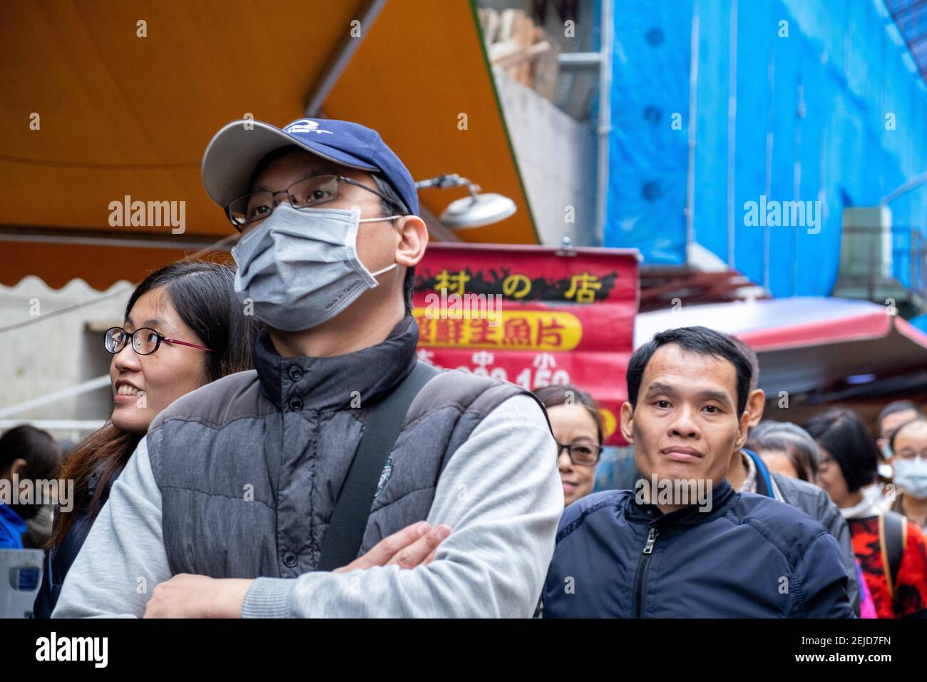 A man looks on while wearing a respirator mask during the celebration ...