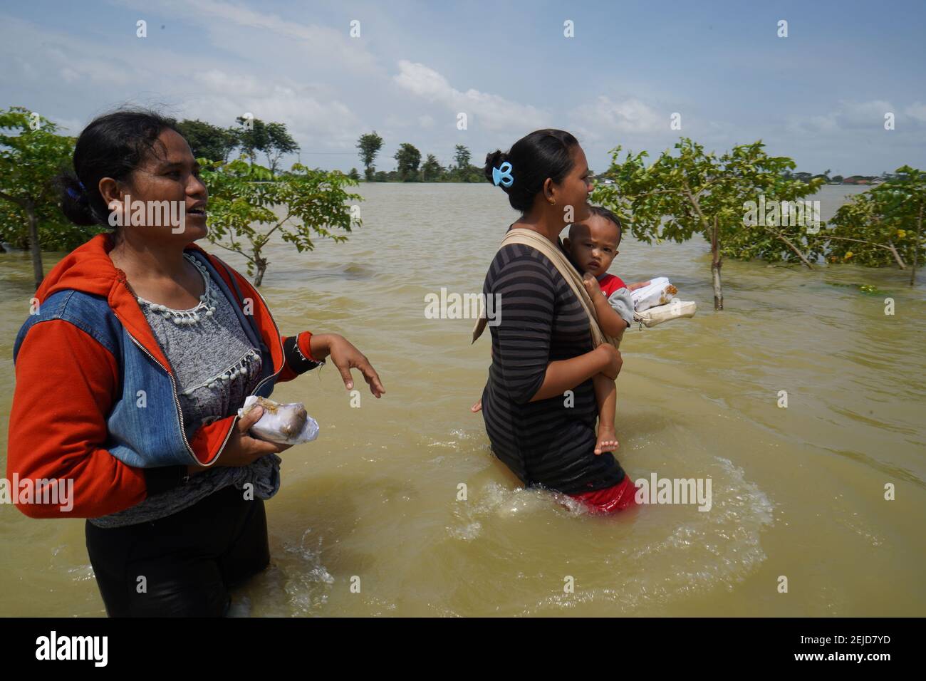 West Java, Indonesia. 22nd Feb, 2021. People walk through flood water ...