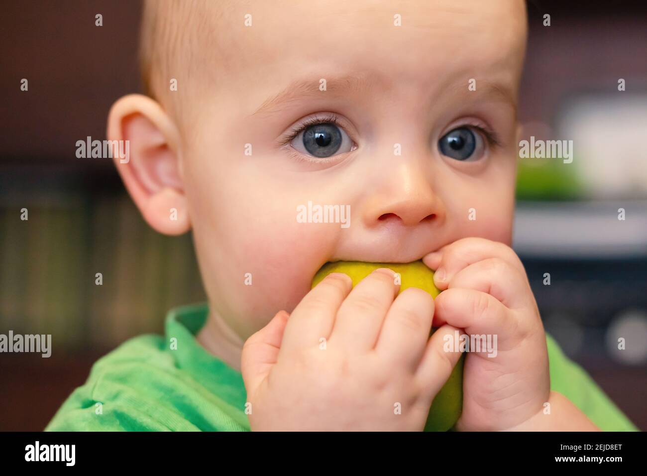 Caucasian baby boy face with apple. Close up. First baby food. Child ...