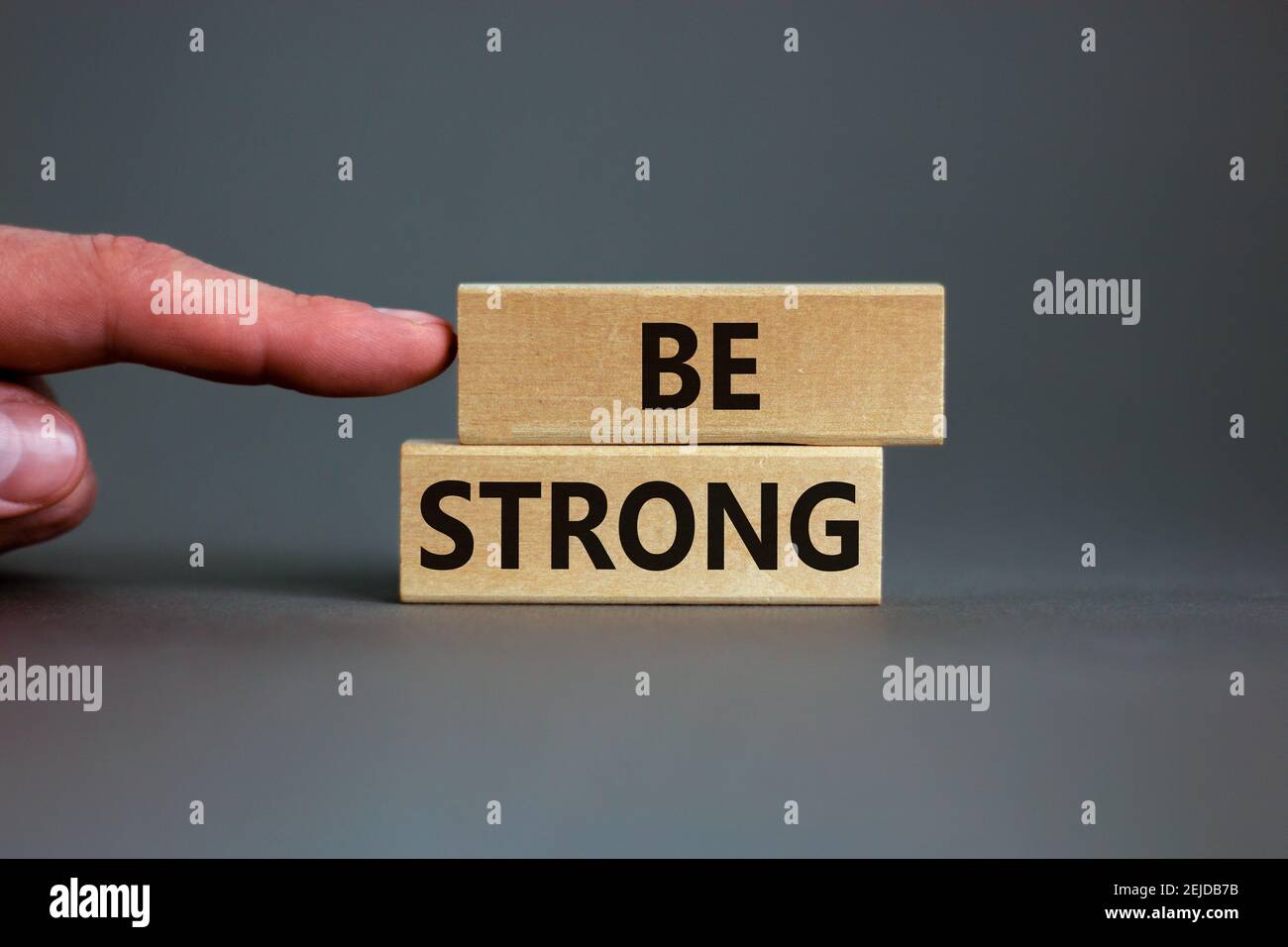 Be strong symbol. Wooden blocks with words 'be strong'. Beautiful grey ...
