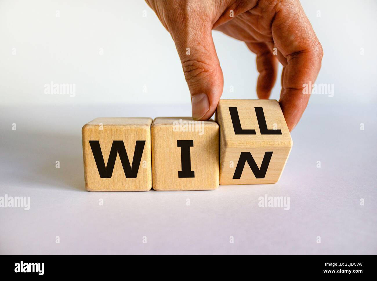 We will win symbol. Businessman turns cubes and changes the word will ...