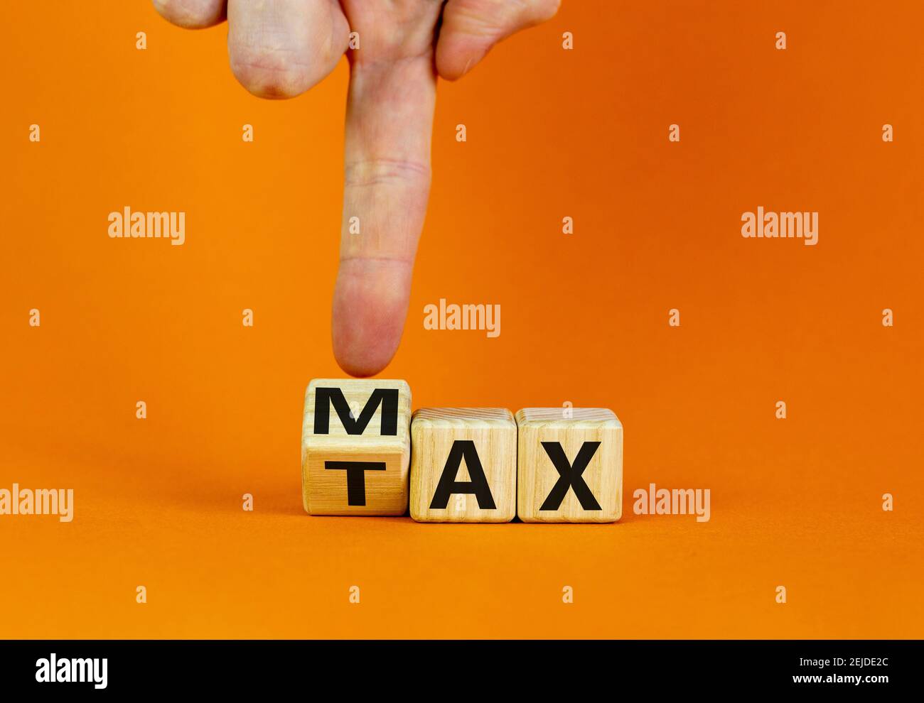 Max tax symbol. Businessman turns the wooden cubes with words 'max tax ...