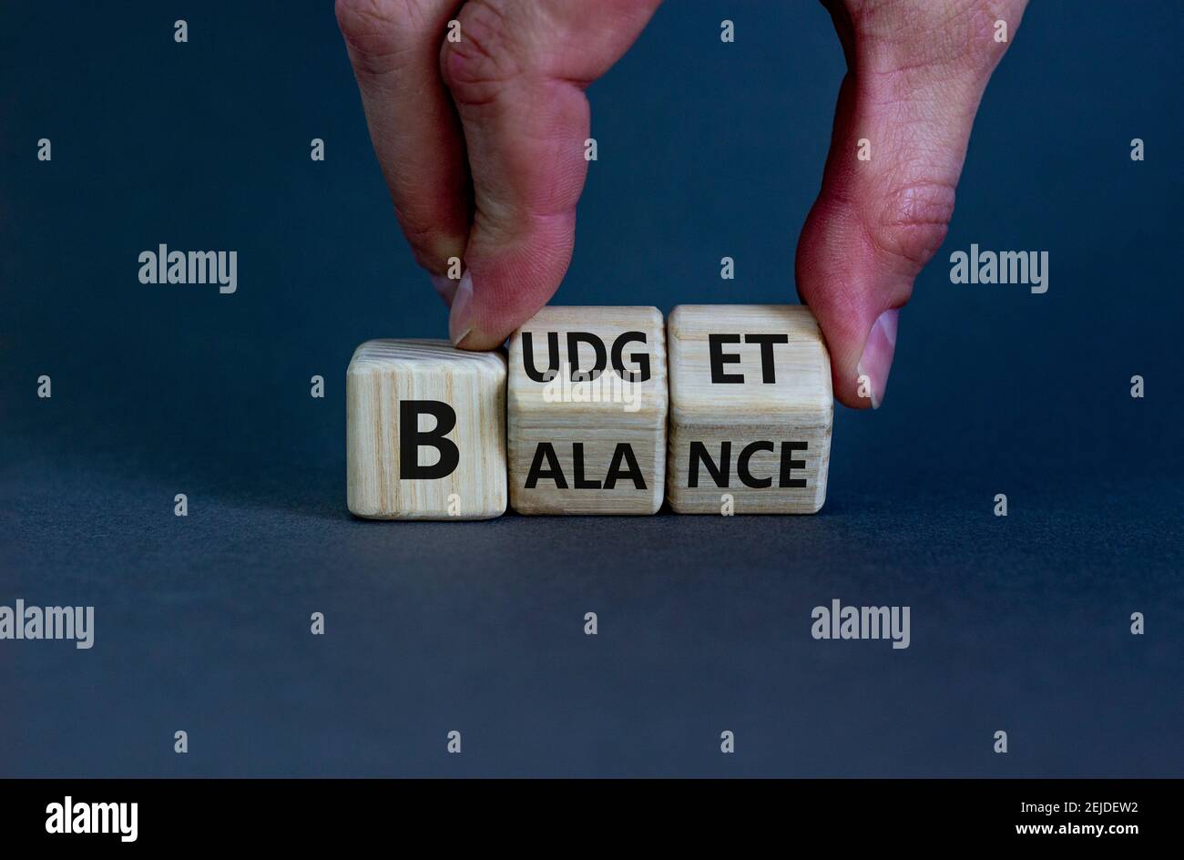 Budget or balance symbol. Businessman turns wooden cubes and changes ...